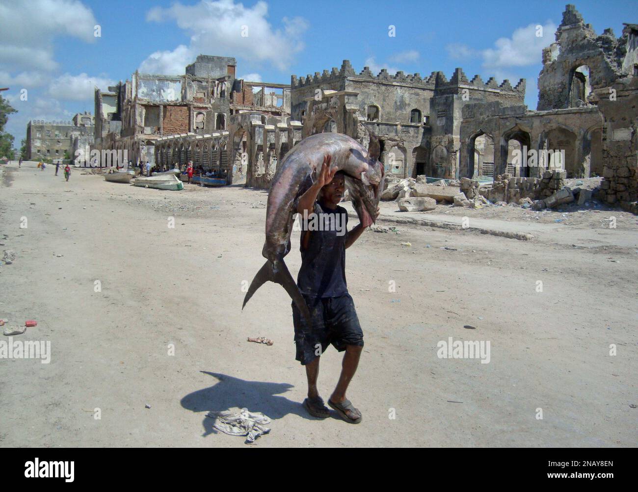 A Somali fisherman carries a swordfish to market on his shoulders in ...