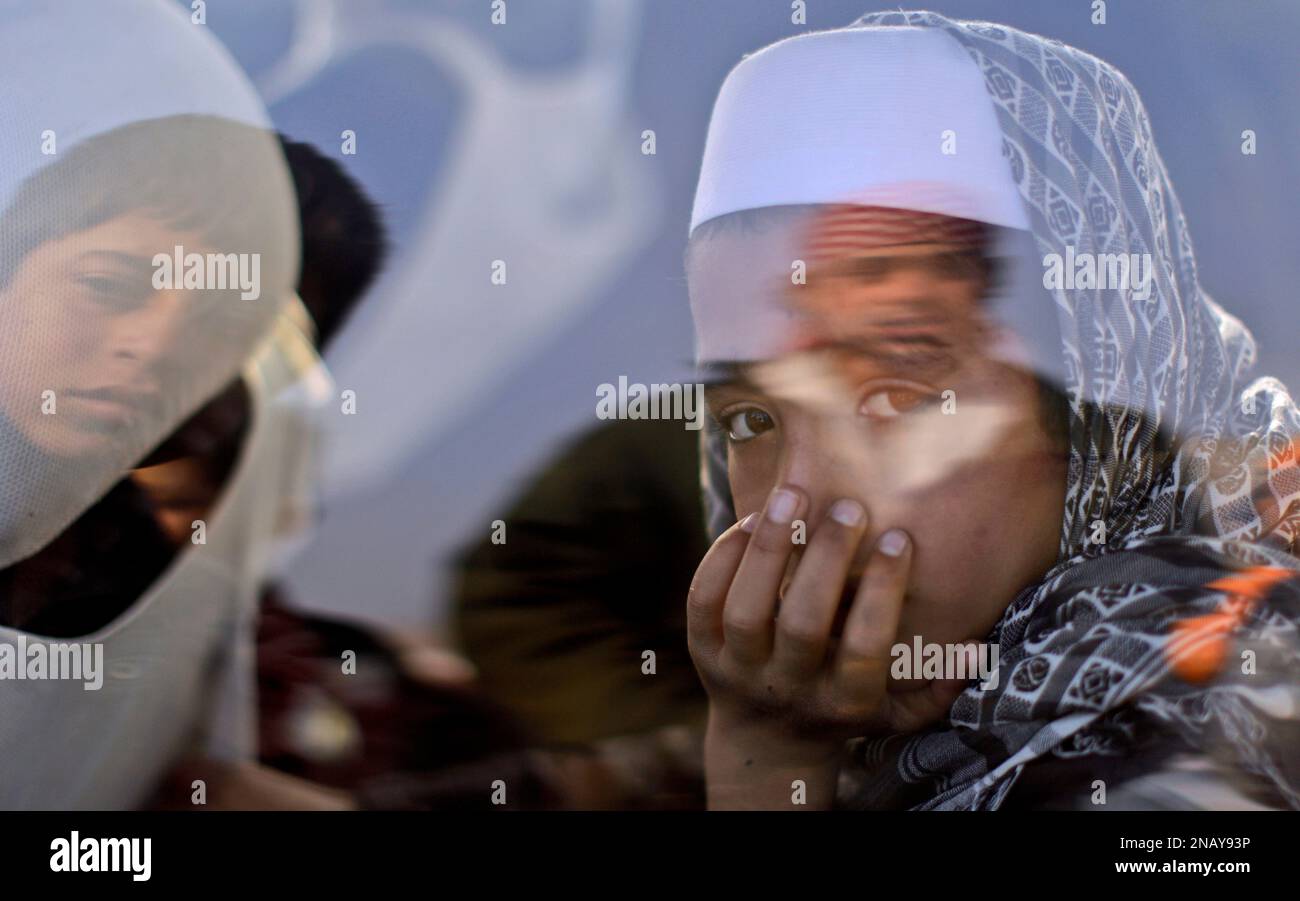Afghan boy, Khalid Ghul, 10, looks on while sitting inside a car at an ...
