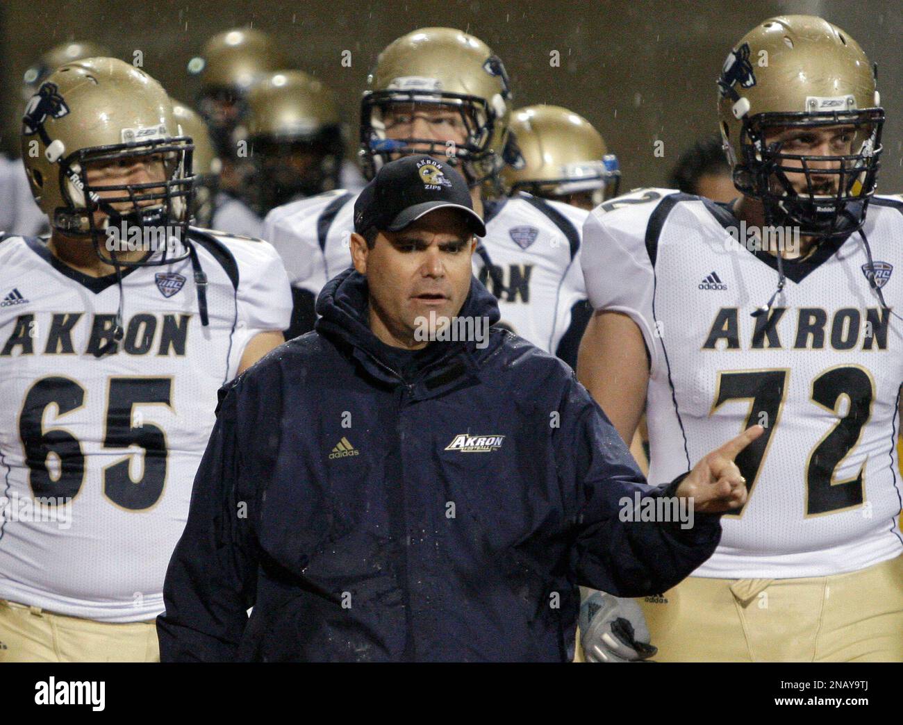 Akron head coach Rob Ianello leads center Adam Bice (65) and guard Zac ...