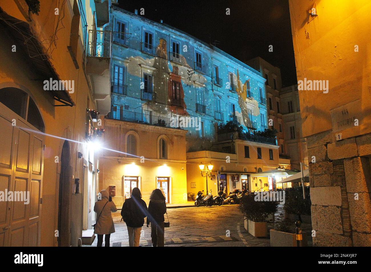 Gaeta, Italy. People walking on a city street illuminated during the ...