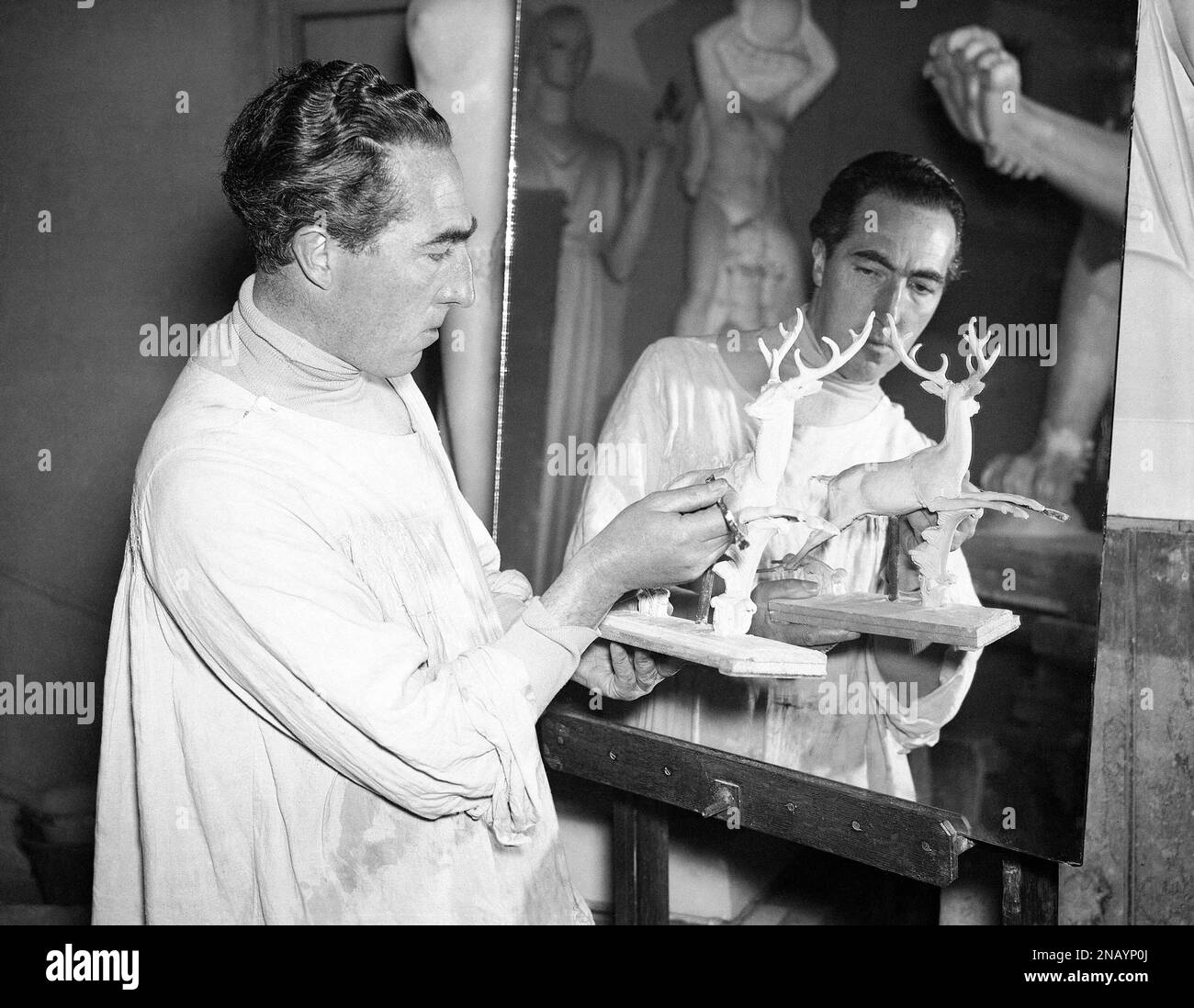 Alfred Frank Hardiman, the sculptor at work observing with the aid of a ...
