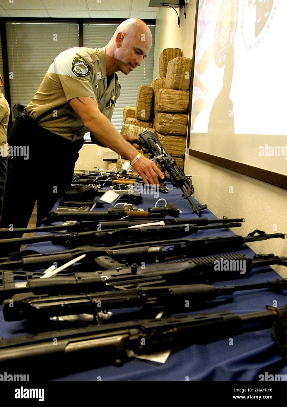 Pinal County Sheriff Paul Babeu checks out one of the seized weapons ...