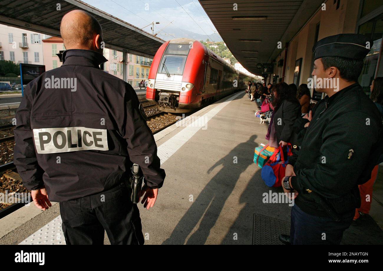 French gendarme and policeman wait to check a train coming from Italy ...