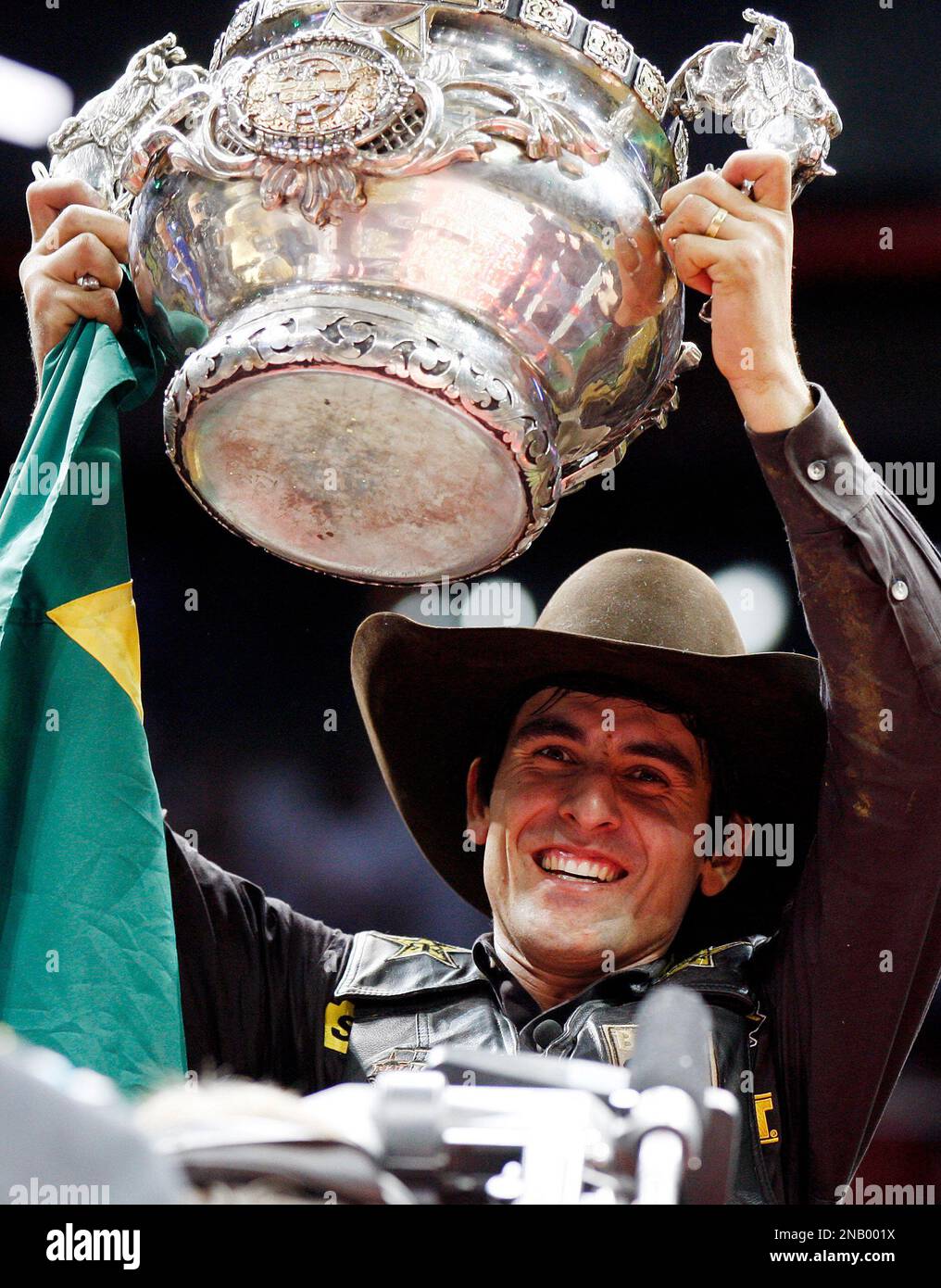 Silvano Alves, of Brazil, hoists a trophy after winning the ...