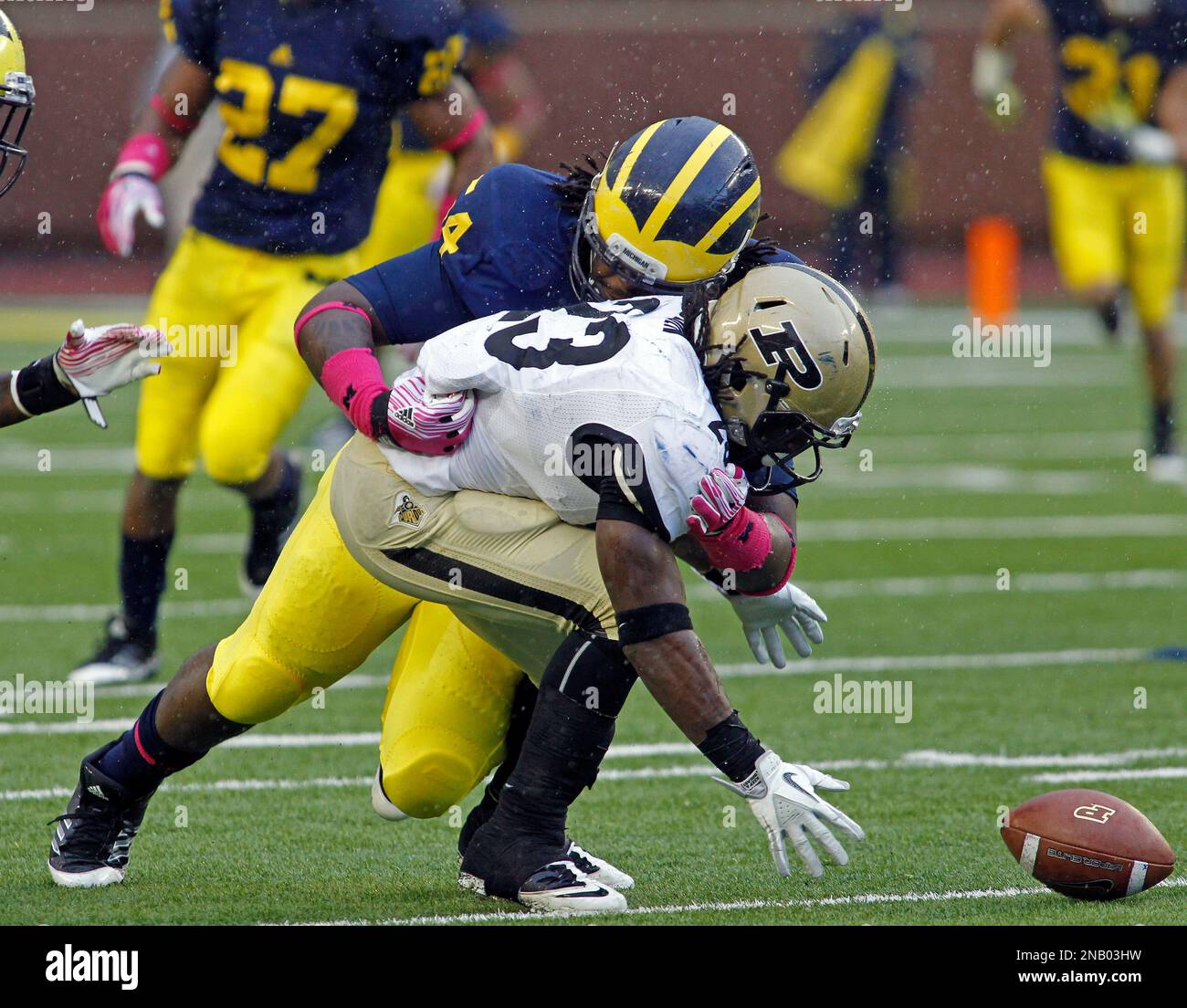 Michigan defensive tackle Richard Ash (54) tackles Purdue running back ...