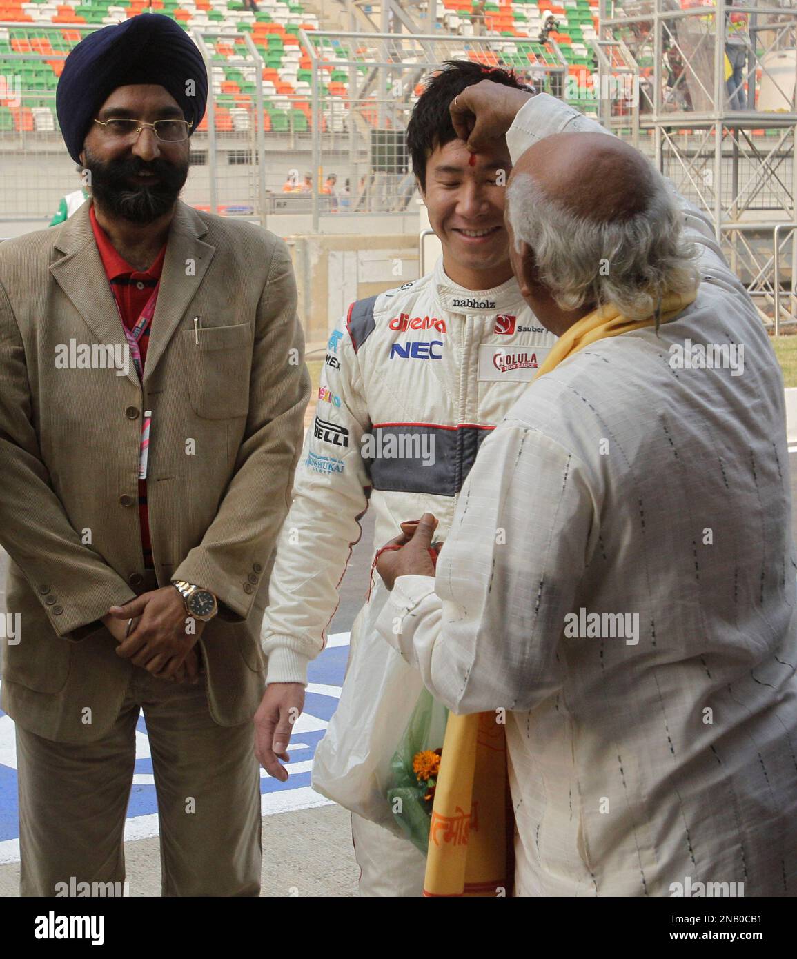 An Indian priest applies a traditional vermilion mark to BMW Sauber ...