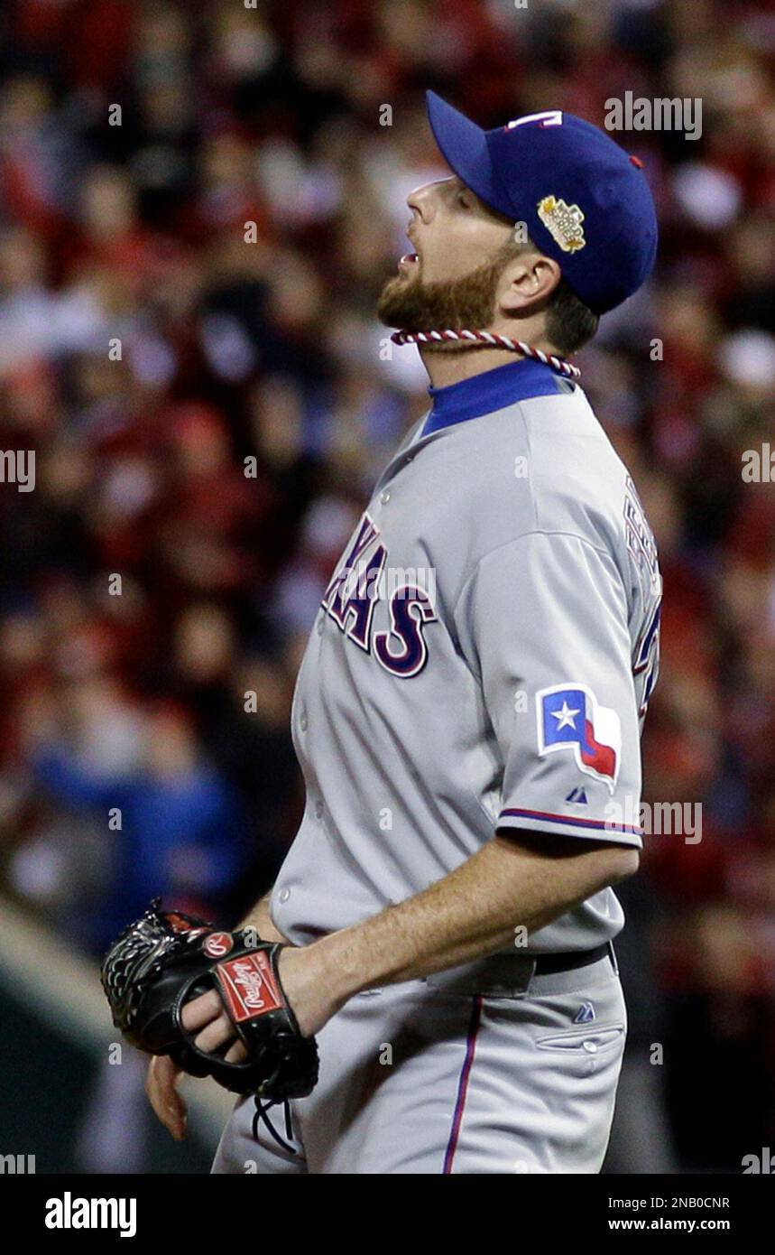 Texas Rangers relief pitcher Scott Feldman reacts after St. Louis Cardinals' Lance Berkman hit a ...