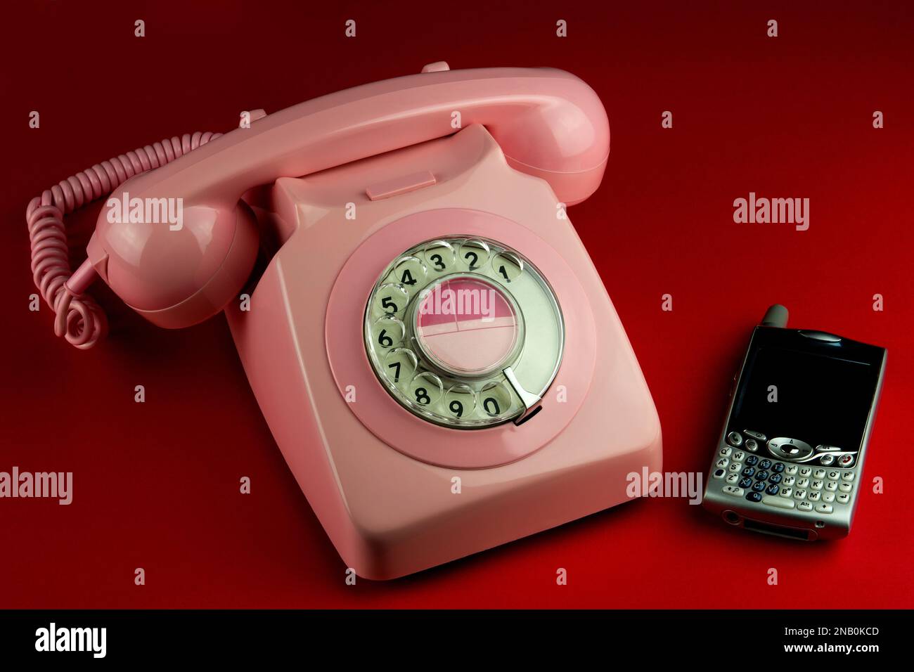 Vintage cellphone and pink telephone on a red table top Stock Photo - Alamy