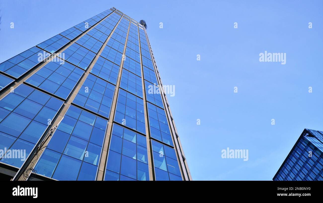 Bottom view of modern skyscrapers in business district against blue sky ...