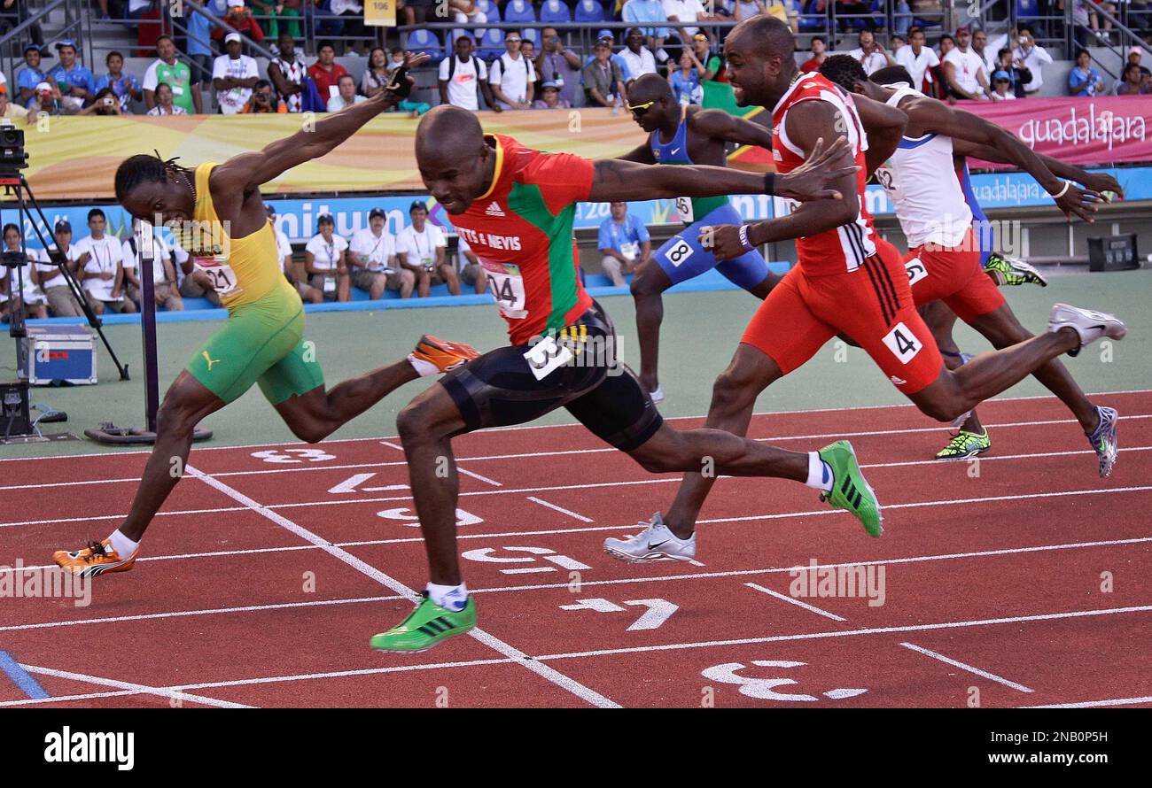 Lerone Clarke, of Jamaica, left, crosses the finish line to win the ...