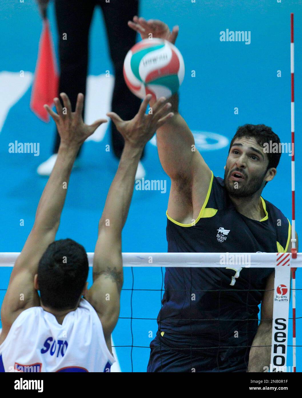 Brazil's Thiago Alves, right, spikes the ball over Puerto Rico's Hector ...