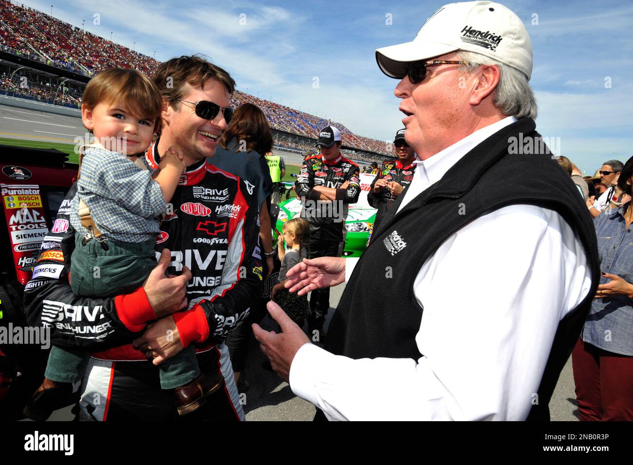 Jeff Gordon (24) holds his son and speaks with team owner Rick Hendrick ...