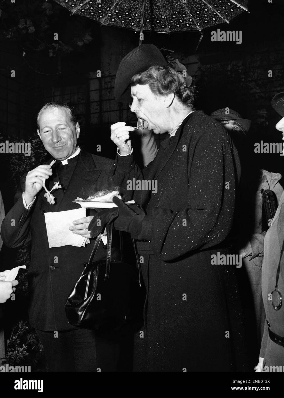 Mrs. Eleanor Roosevelt samples a drum stick of hamburger, corn flakes ...