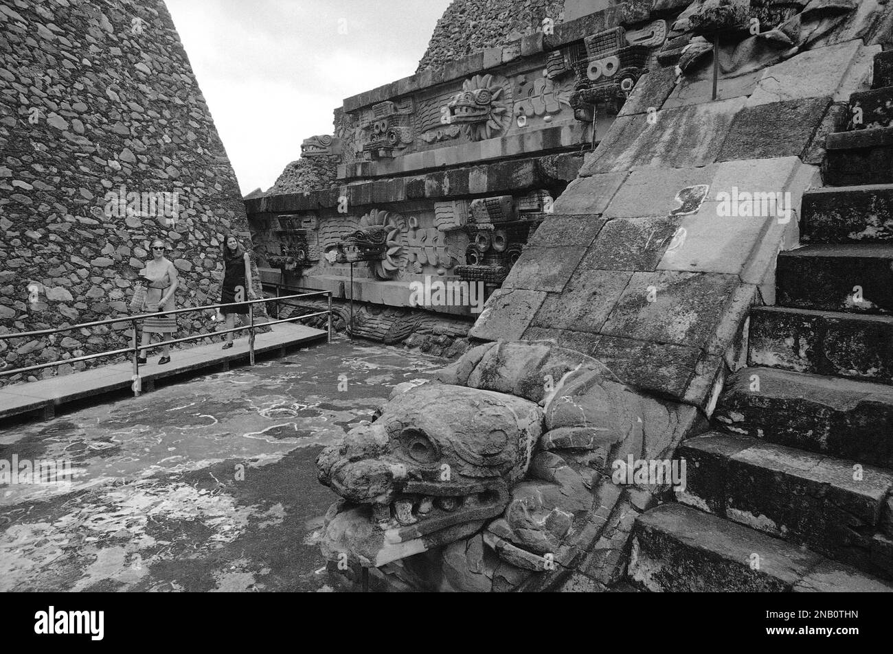 Visitors view the grotesque sculpture on the Temple of Quetzalcoatl ...