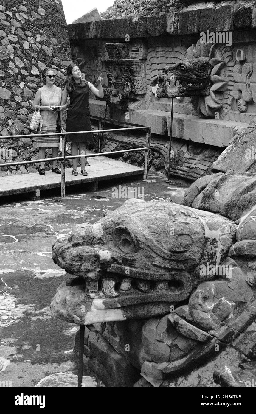 Visitors view the grotesque sculpture on the Temple of Quetzalcoatl ...