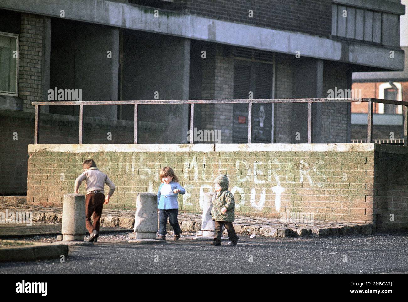 Local children play against a background of political slogans near the ...