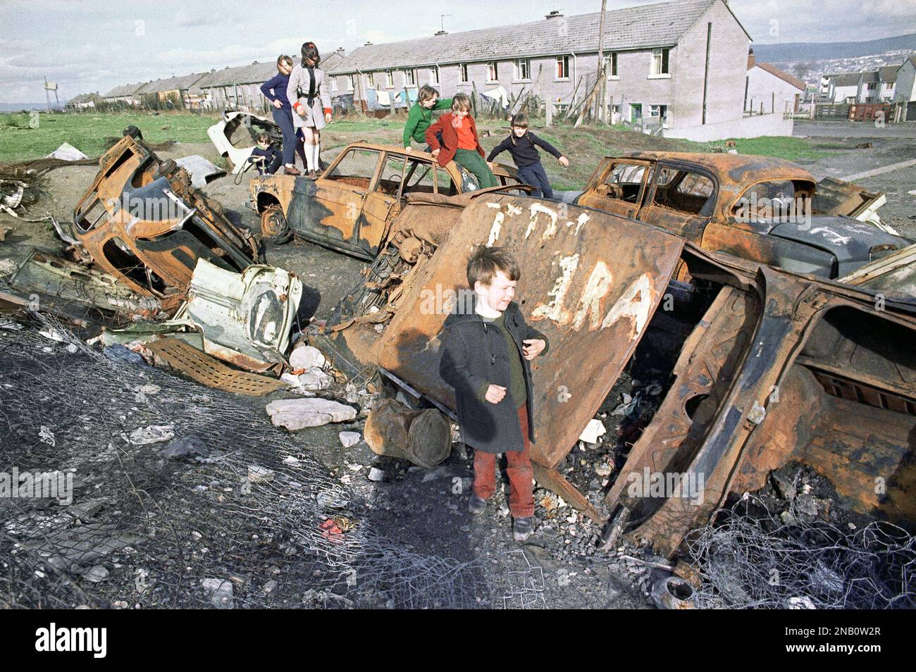 Irish children play around heaps of ruins burnt out cars and trucks ...