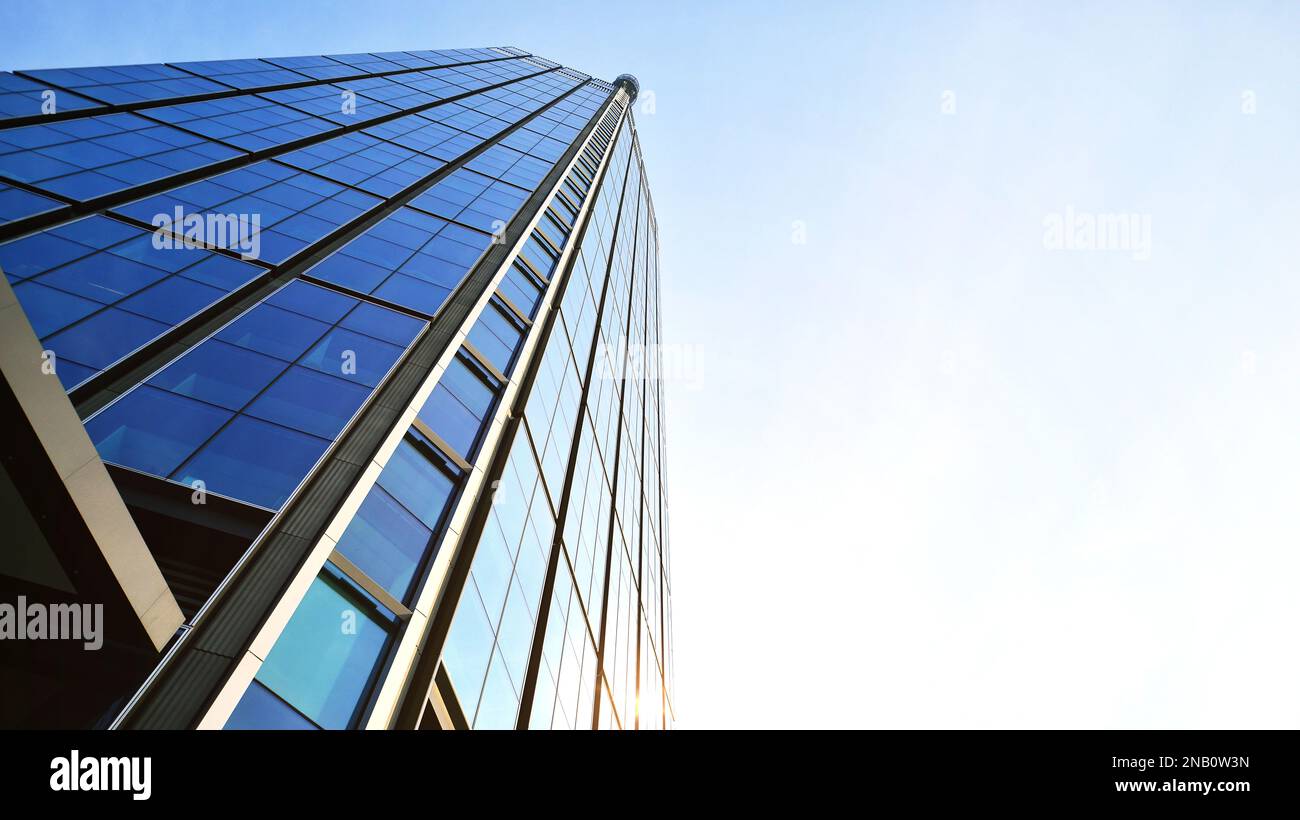 Bottom view of modern skyscrapers in business district against blue sky ...