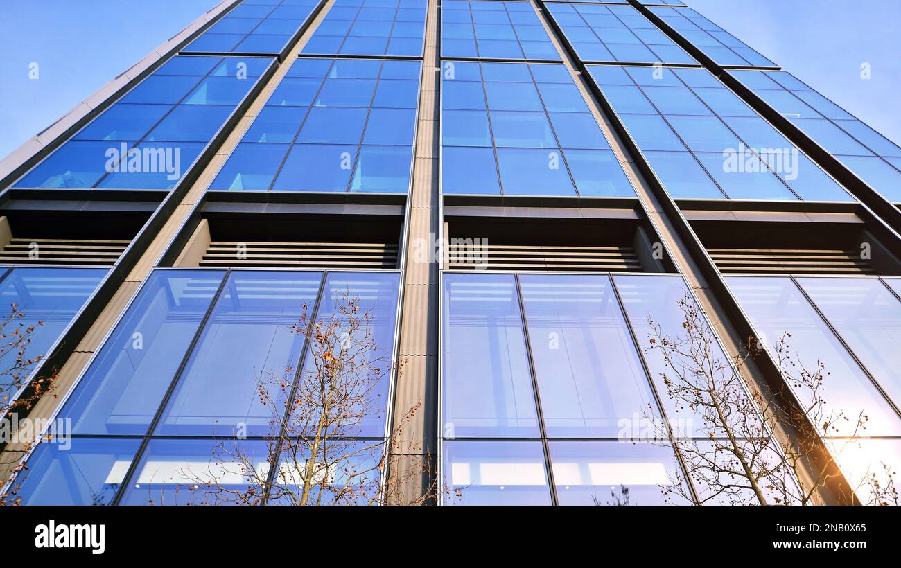 Bottom view of modern skyscrapers in business district against blue sky ...