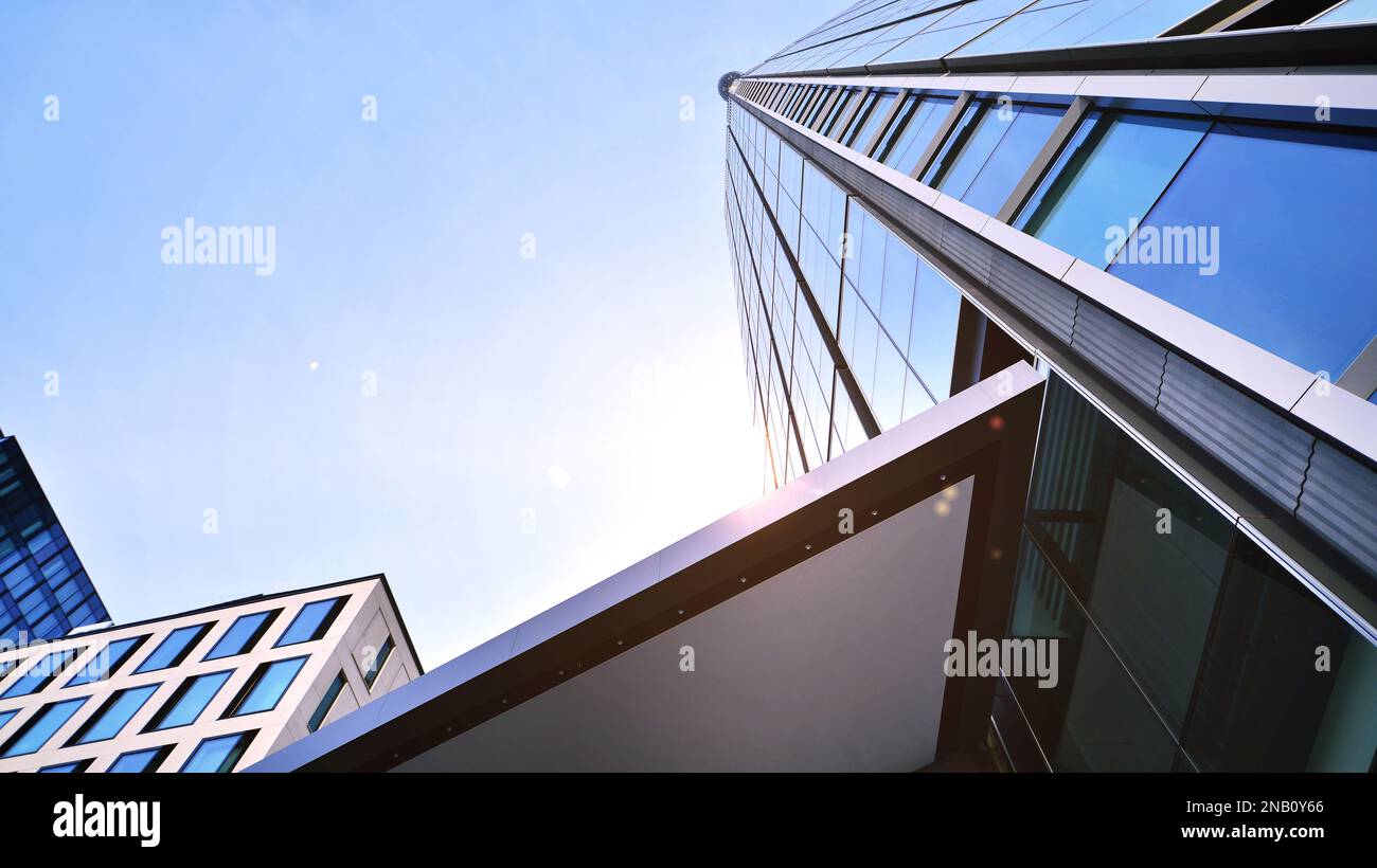 Bottom view of modern skyscrapers in business district against blue sky ...