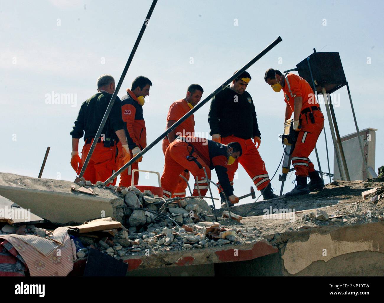 Emergency crews work to rescue people from the rubble and debris of ...