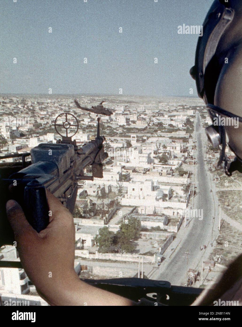 The gunner of a U.S. Army Blackhawk helicopter covers the flight of a ...