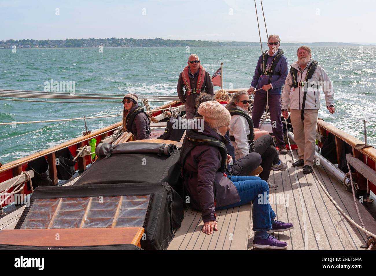 Crew aboard the traditional gaff cutter "Jolie Brise", running downwind ...