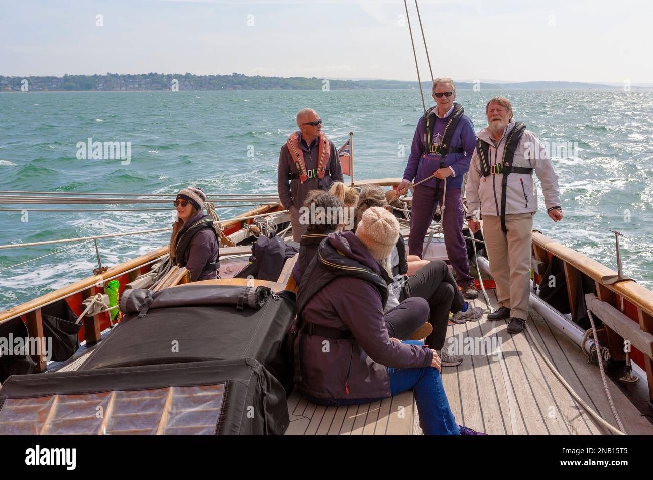 Crew aboard the traditional gaff cutter "Jolie Brise", running downwind ...