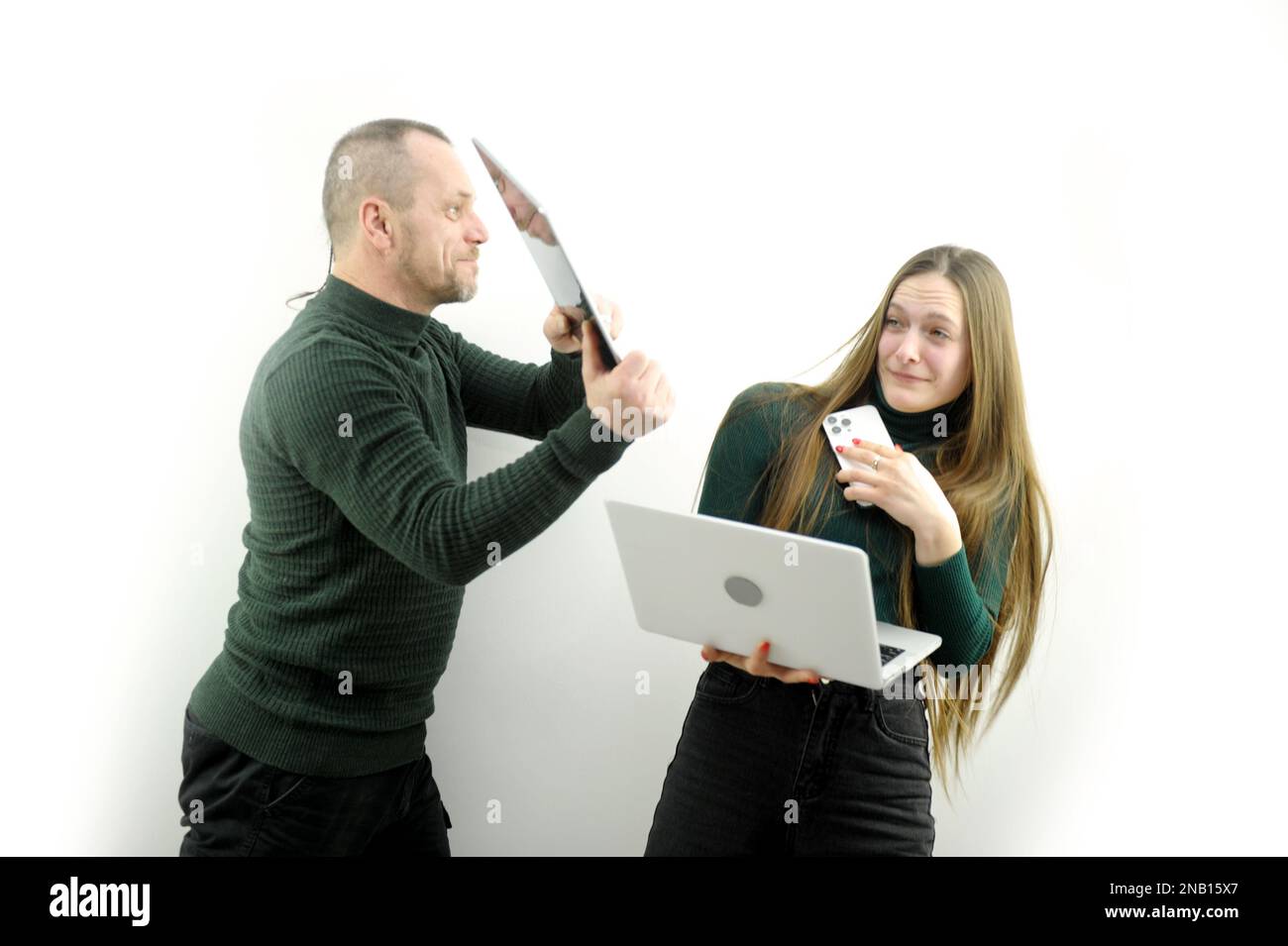 man and woman are fighting using laptop tablet and phone technology ...