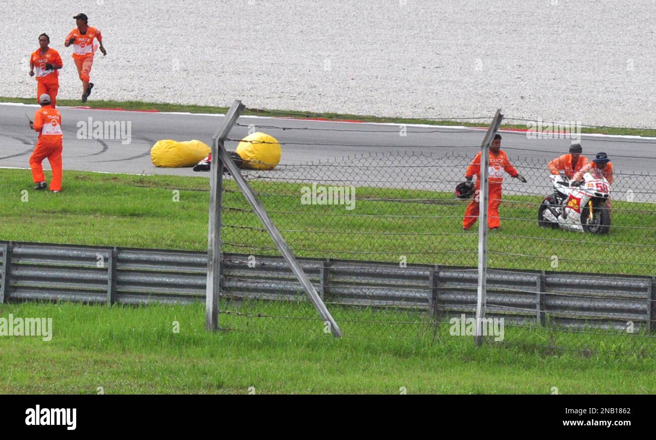 Italy's rider Marco Simoncelli lies on the racetrack after a crash ...