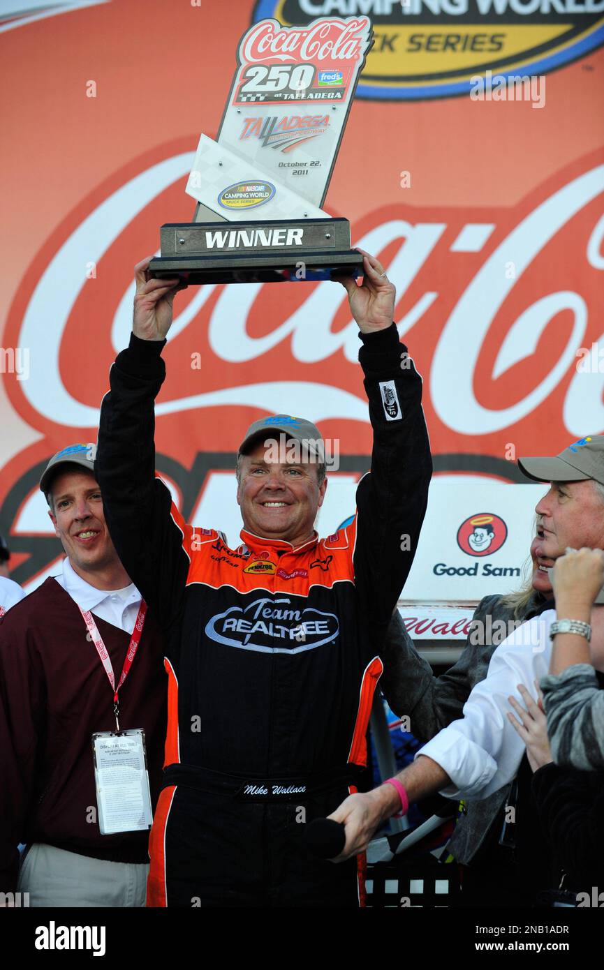 NASCAR truck driver Mike Wallace holds the winning trophy after winning ...