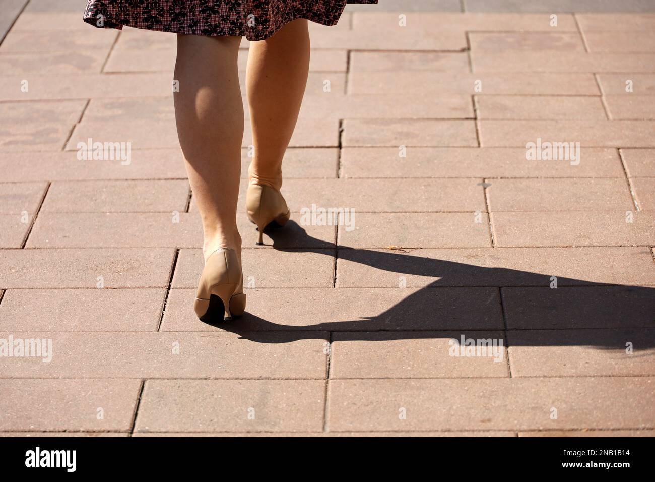 Female legs in shoes on high heels in sunny day. Woman in summer dress ...