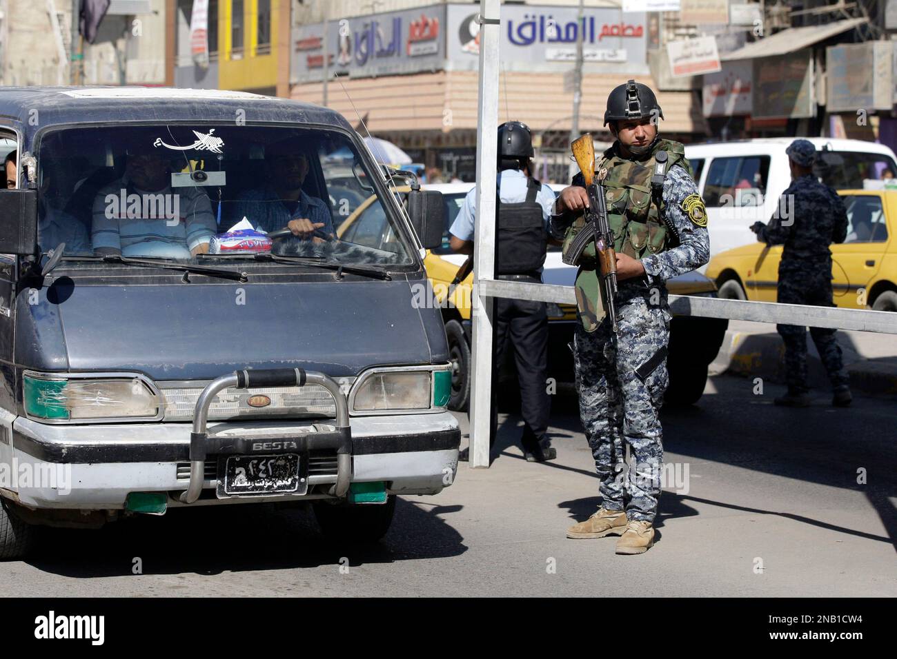Iraqi police officers stand guard at a checkpoint in central Baghdad ...