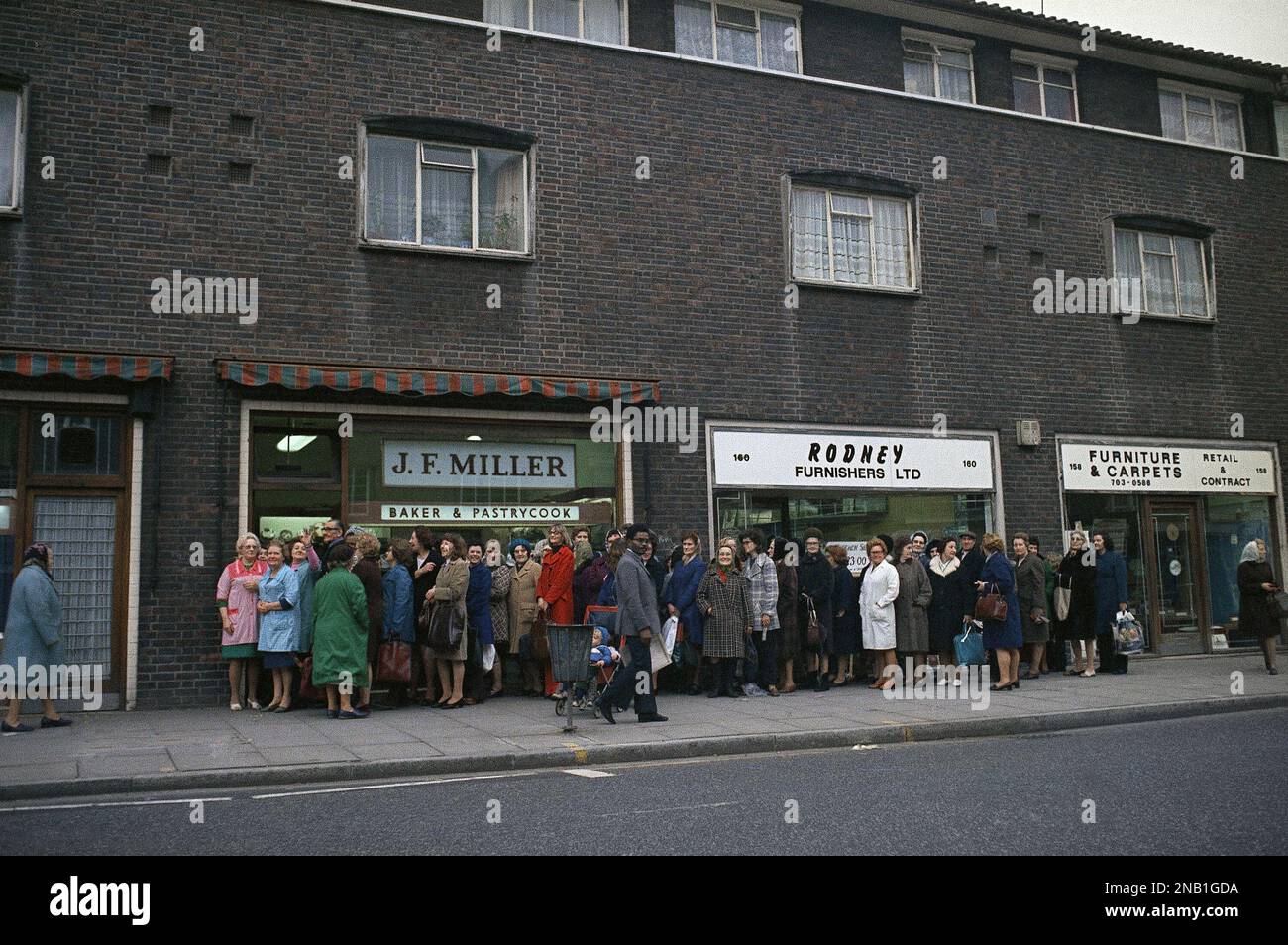London housewives stand in line at a bakery in Old Kent Road as a ...