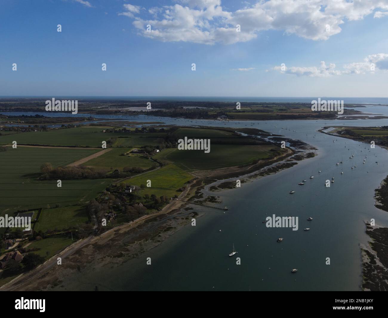 An inlet of Chichester Harbour, looking towards the sea, with farmland ...