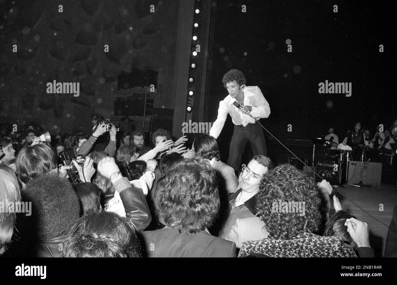 British singer Tom Jones shakes hands with audience members as he ...