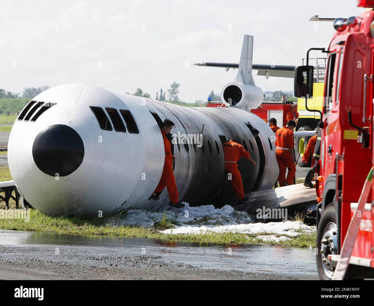 Rescuers search a mock up model of a passenger plane during an airport ...