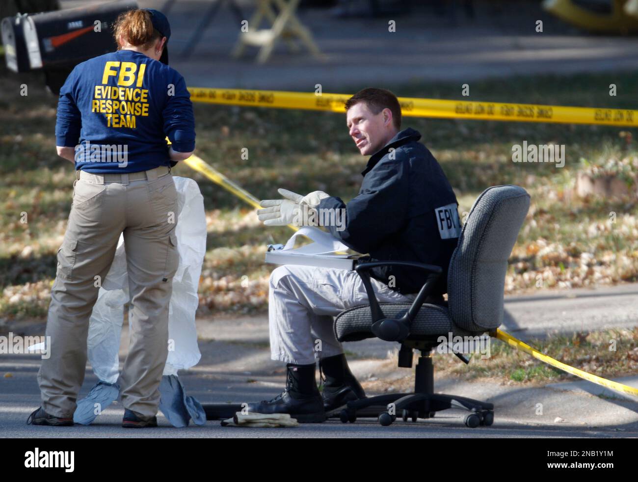 FBI investigators don clean overalls while searching the home of ...