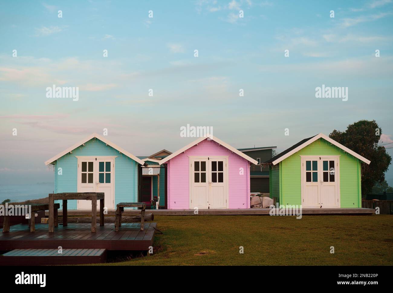 A row of cute colorful beach huts against blue cloudy sunset sky in New ...