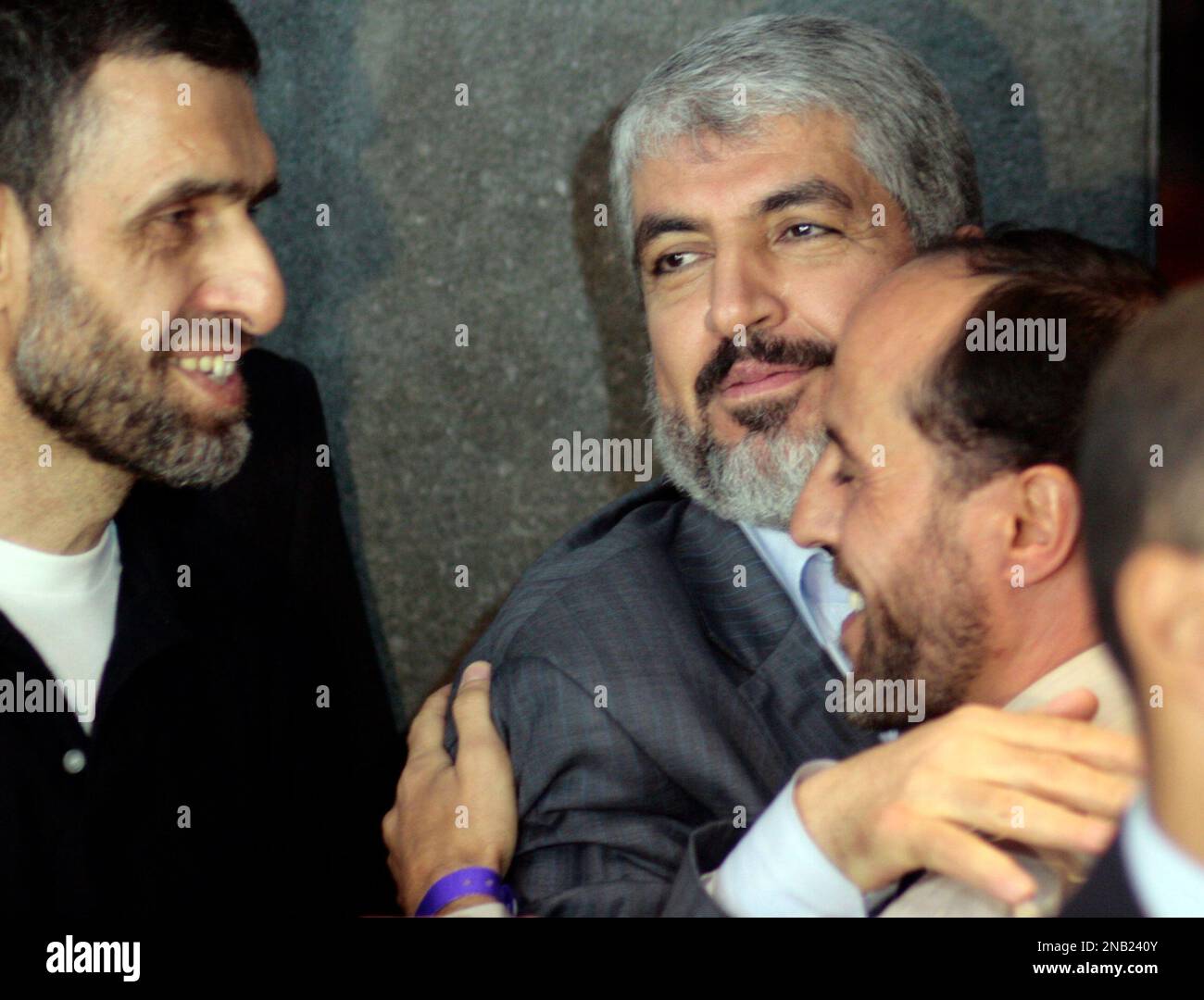 Hamas political leader Khaled Meshal, centre, greets two Palestinian ...