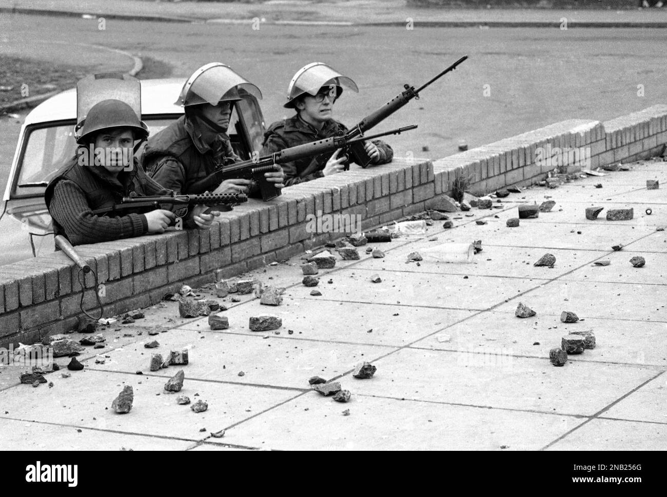 Three British soldiers, two armed with automatic rifles, and man at ...