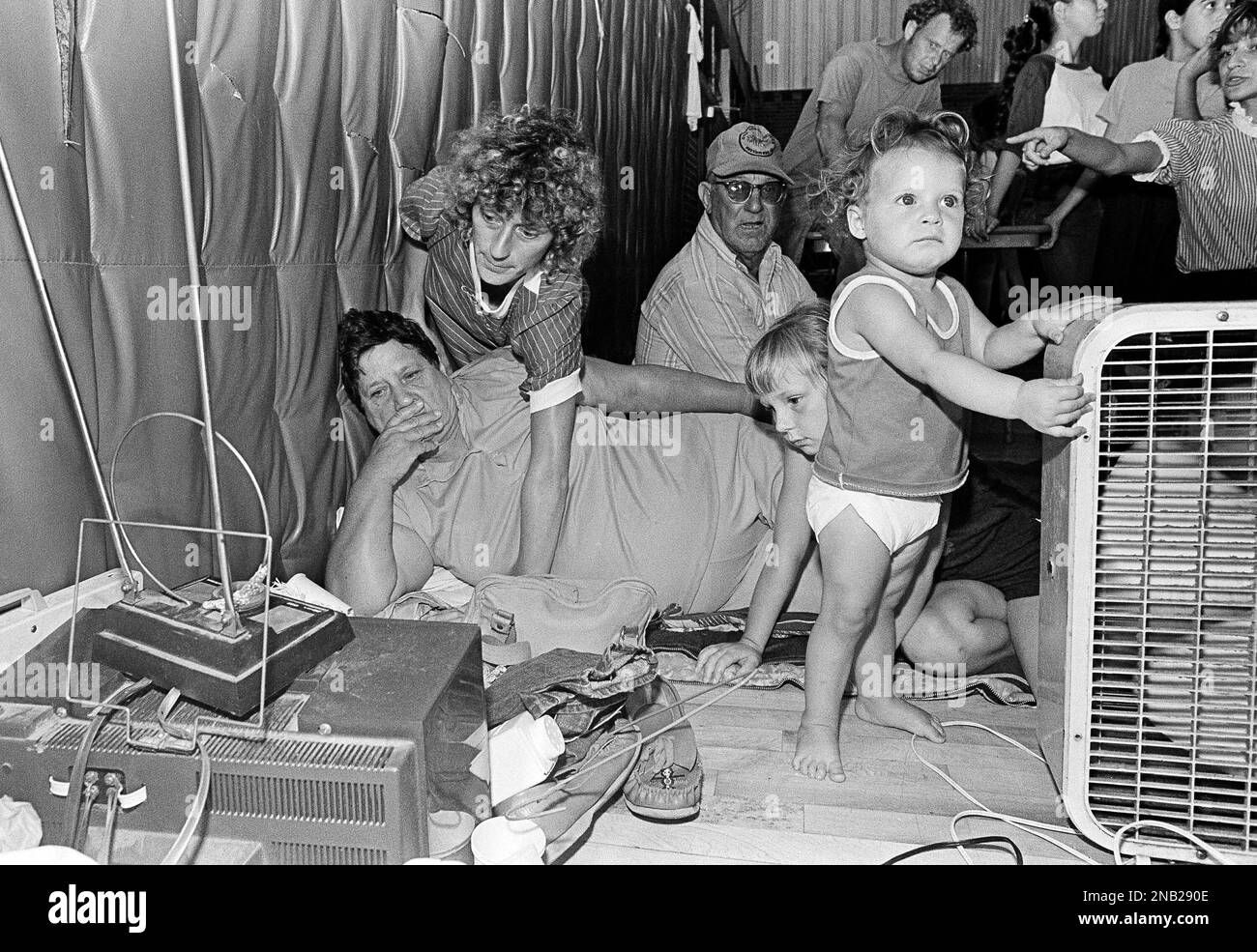 The Dyson family of Cameron, La., keeps a close watch on a portable TV ...