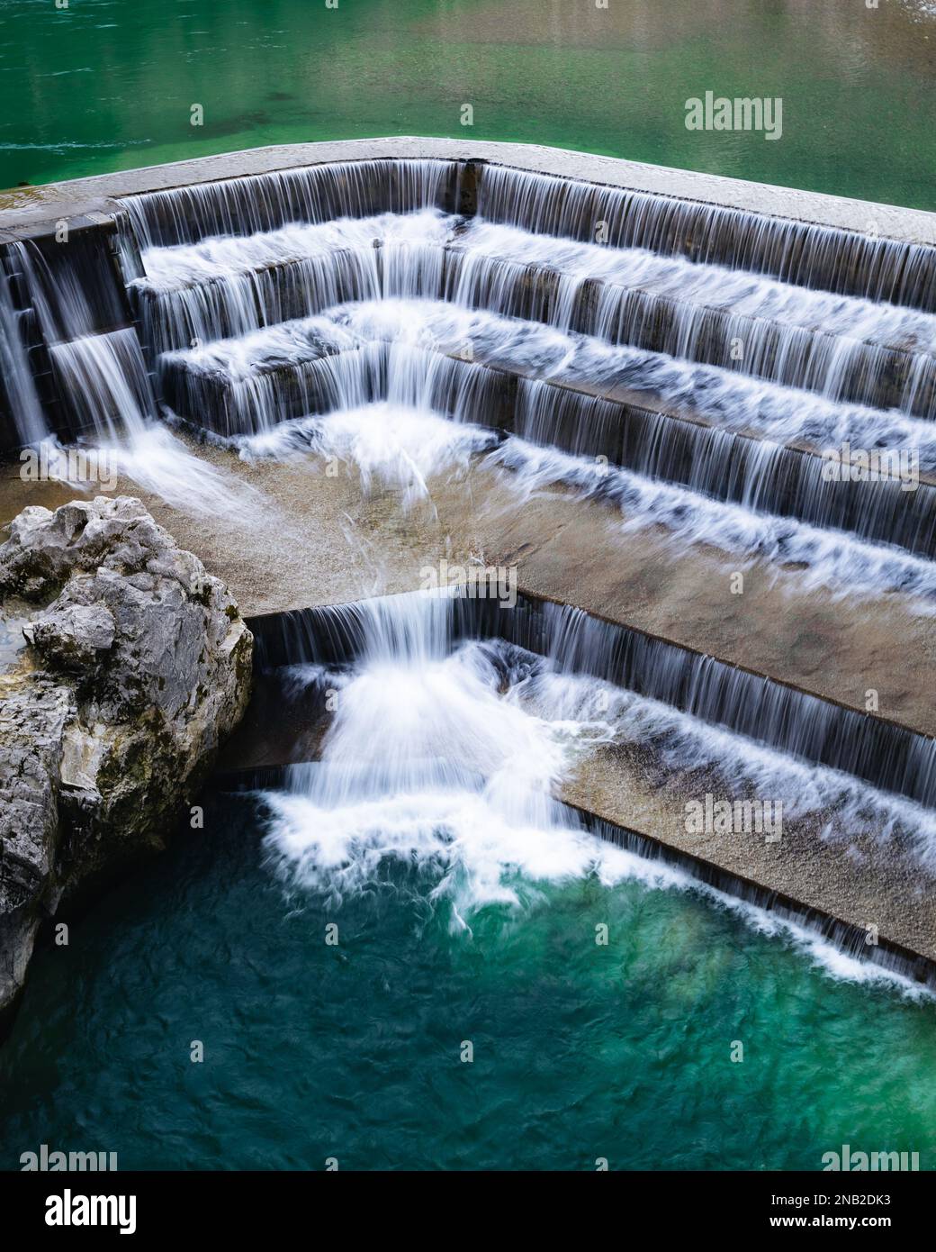 A stunning waterfall cascading over rocks into a blue pool below Stock ...