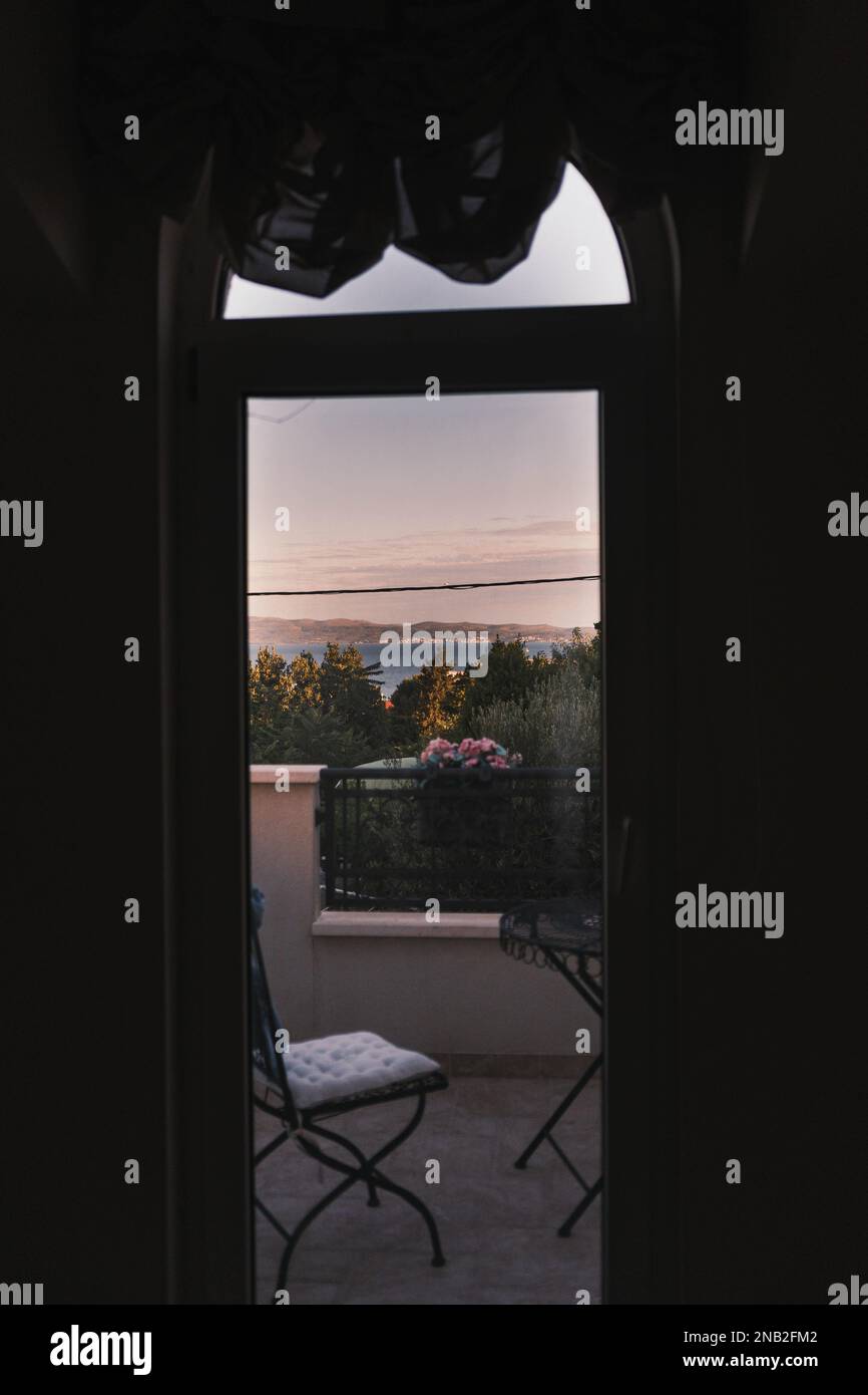 Door to balcony view with sun setting behind clouds Stock Photo - Alamy
