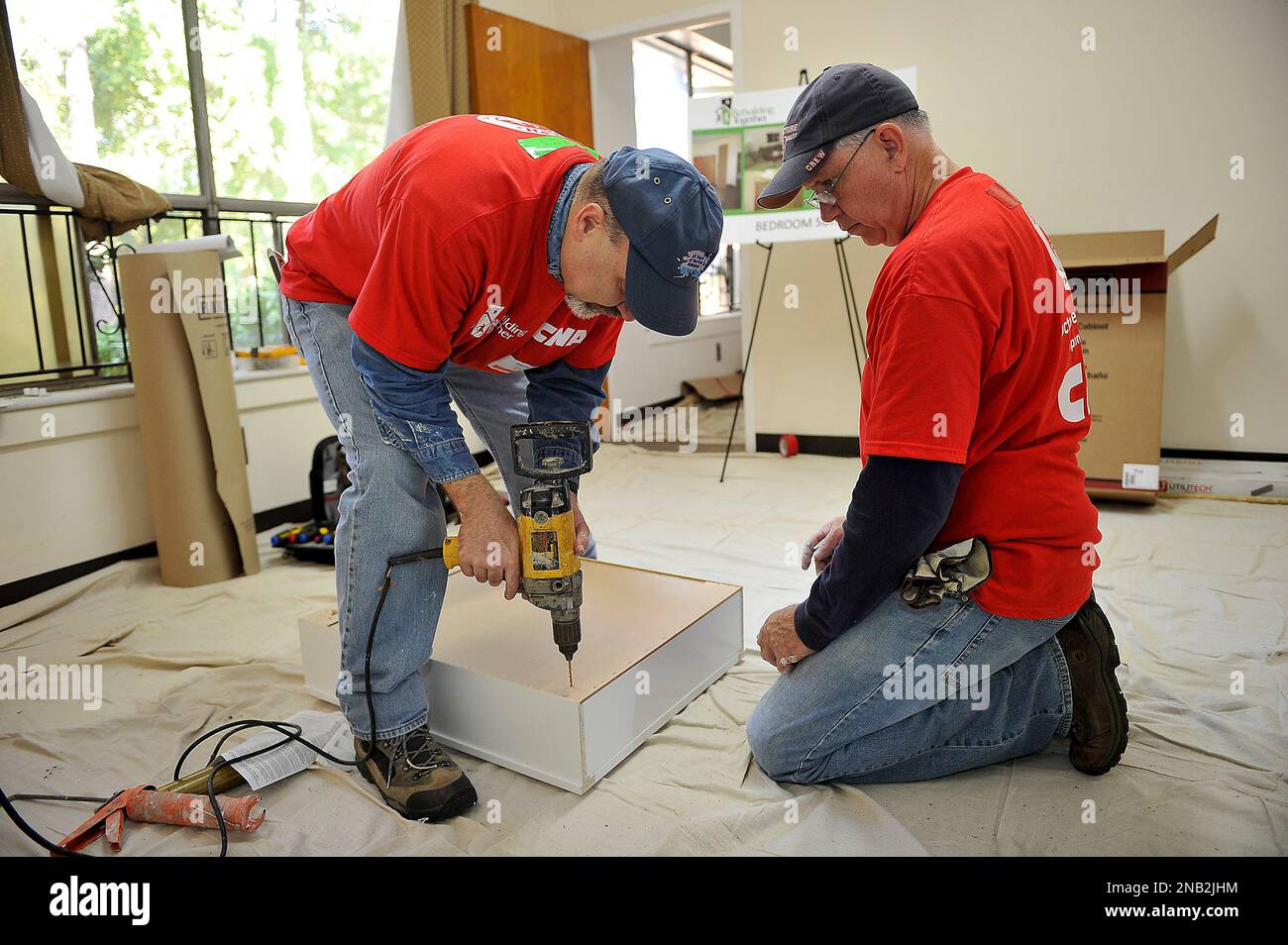 (Left) Pierre Bineau and Gary Fowler work on a medicine cabinet for a ...