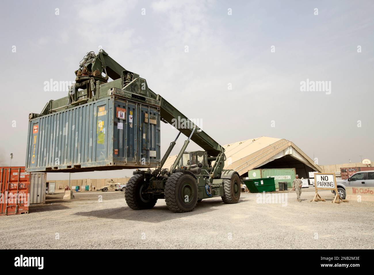 A U.S. army soldier transfers a container at Camp Sather, part of the ...