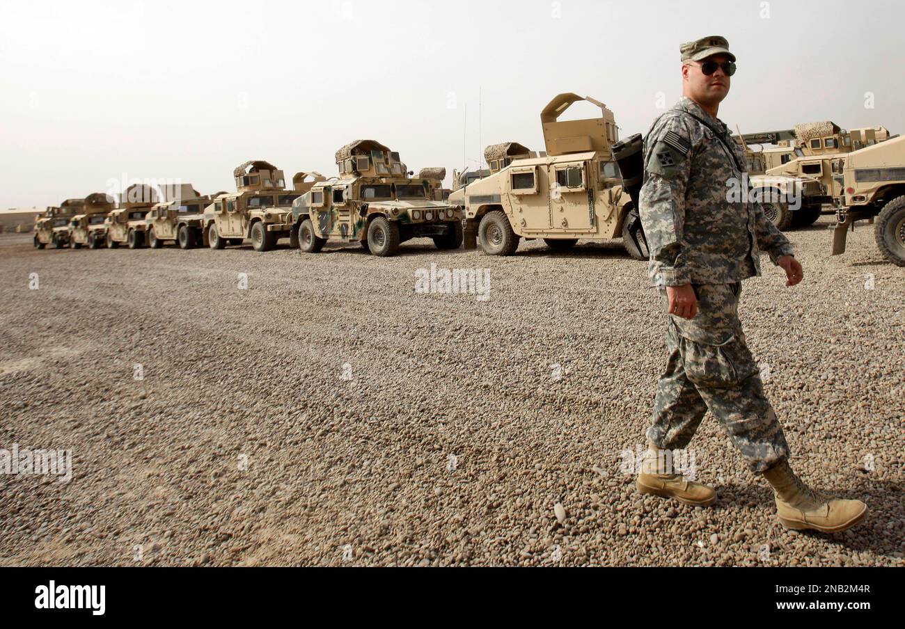 A U.S. army soldier walks past military Humvees which are ready to be ...