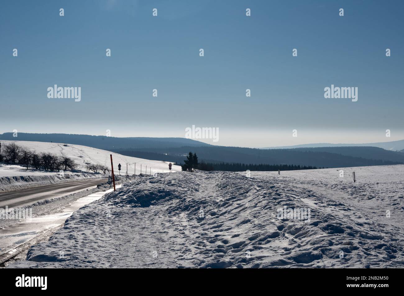 Country road in winter with lots of snow and blue sky, in the high Rhön ...