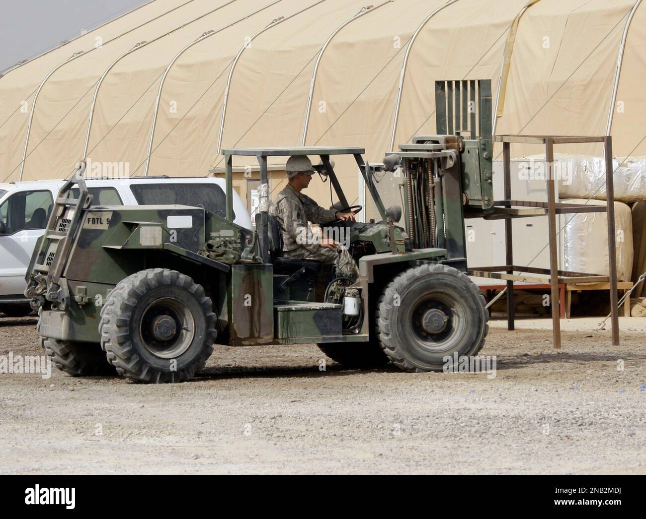 A U.S. army soldier transfers an iron frame at Camp Sather, part of the ...