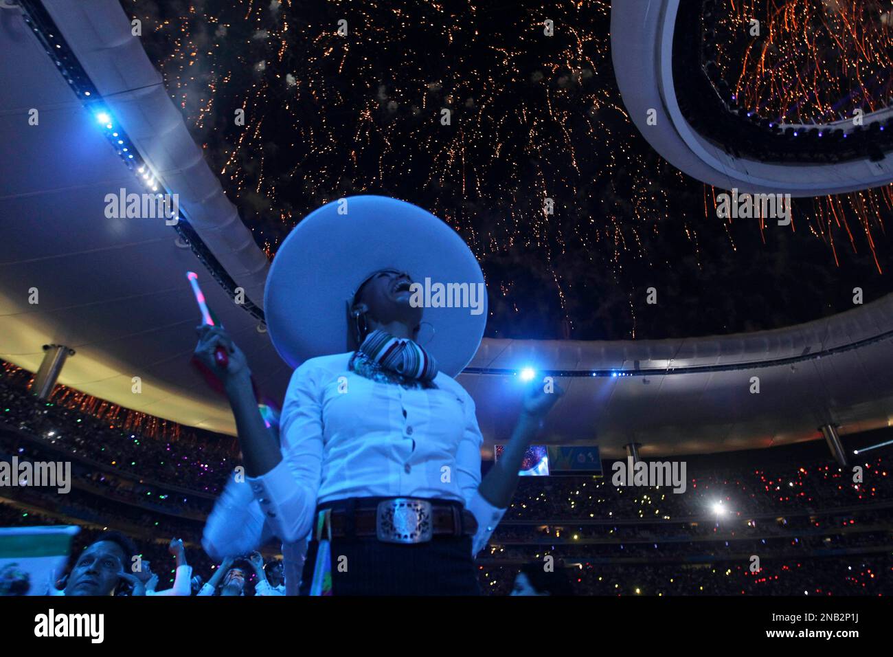 A Mexican athlete gestures as fireworks explode over the Omnilife ...